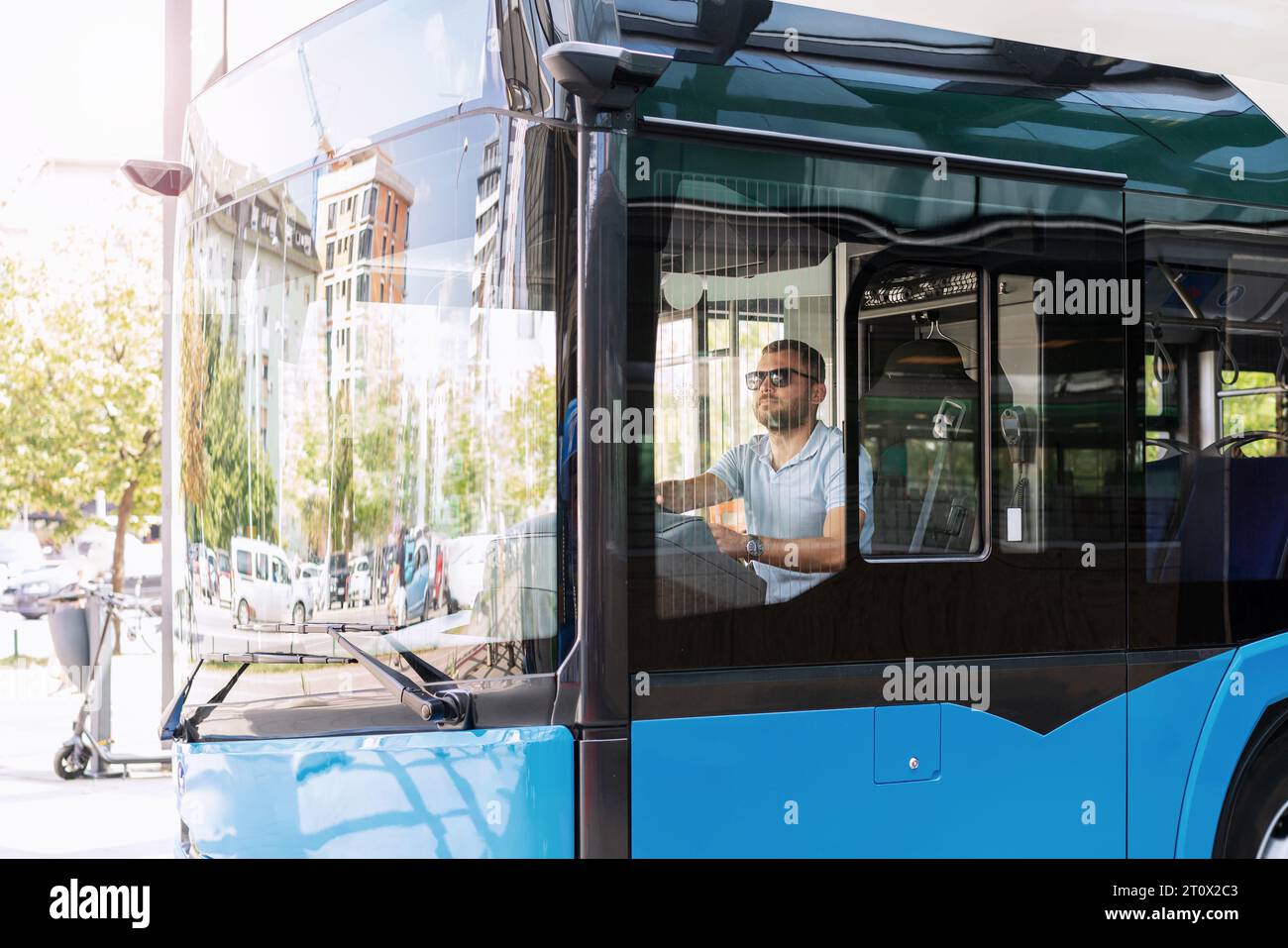 Man wearing sunglasses driving shuttle city bus. Bus driver occupation ...