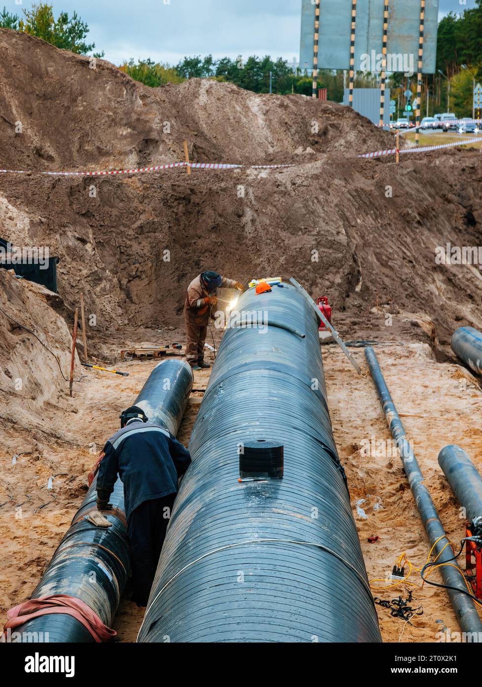 Workers in protective mask welding water supply pipes Stock Photo - Alamy
