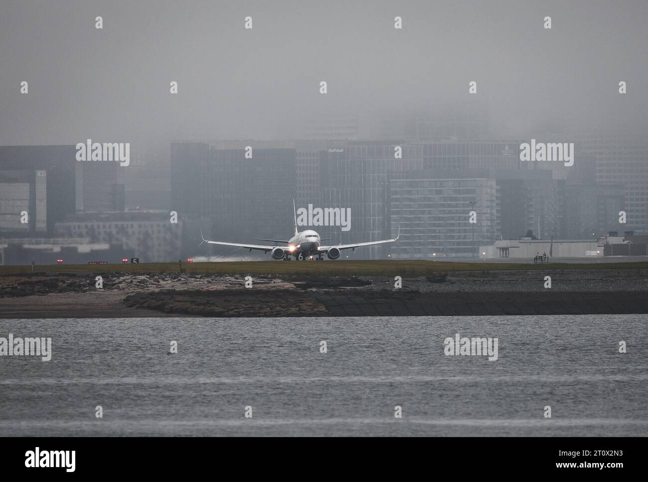 An airplane taking off from an airport in Boston with fog obscuring the ...
