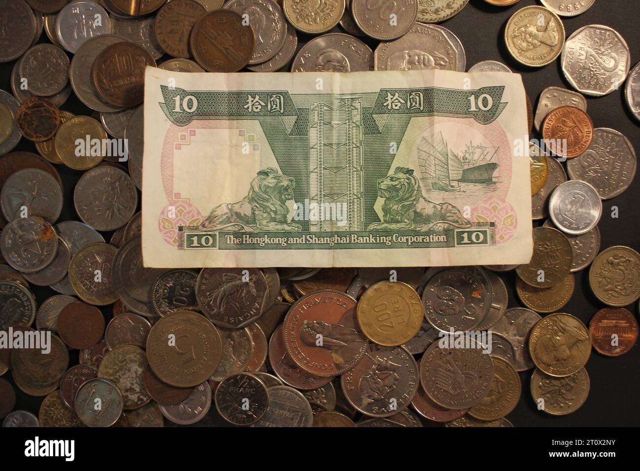A ten yuan note with lots of international coins Stock Photo - Alamy