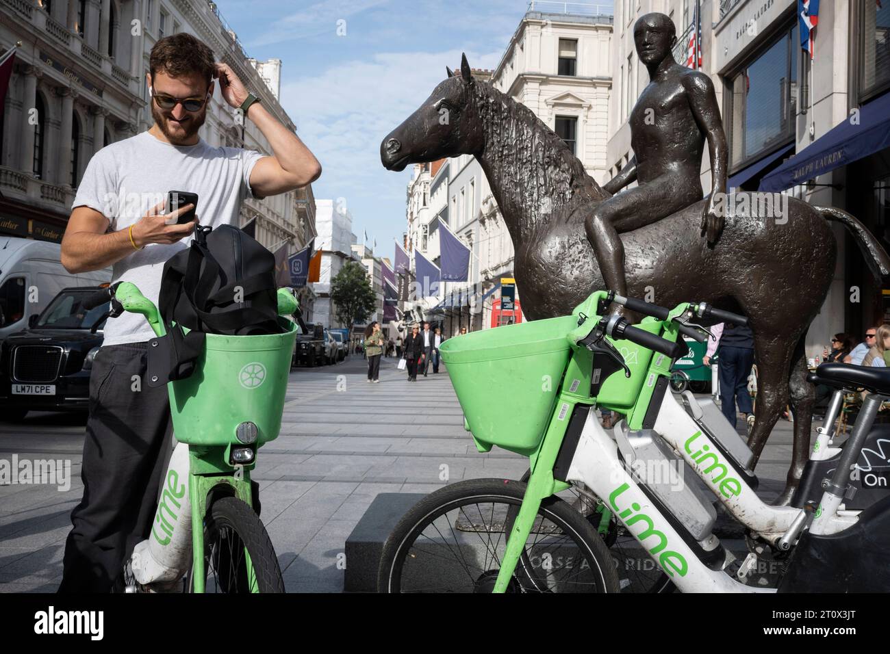 A bike rider alongside the sculpture entitled Horse and Rider stands ...