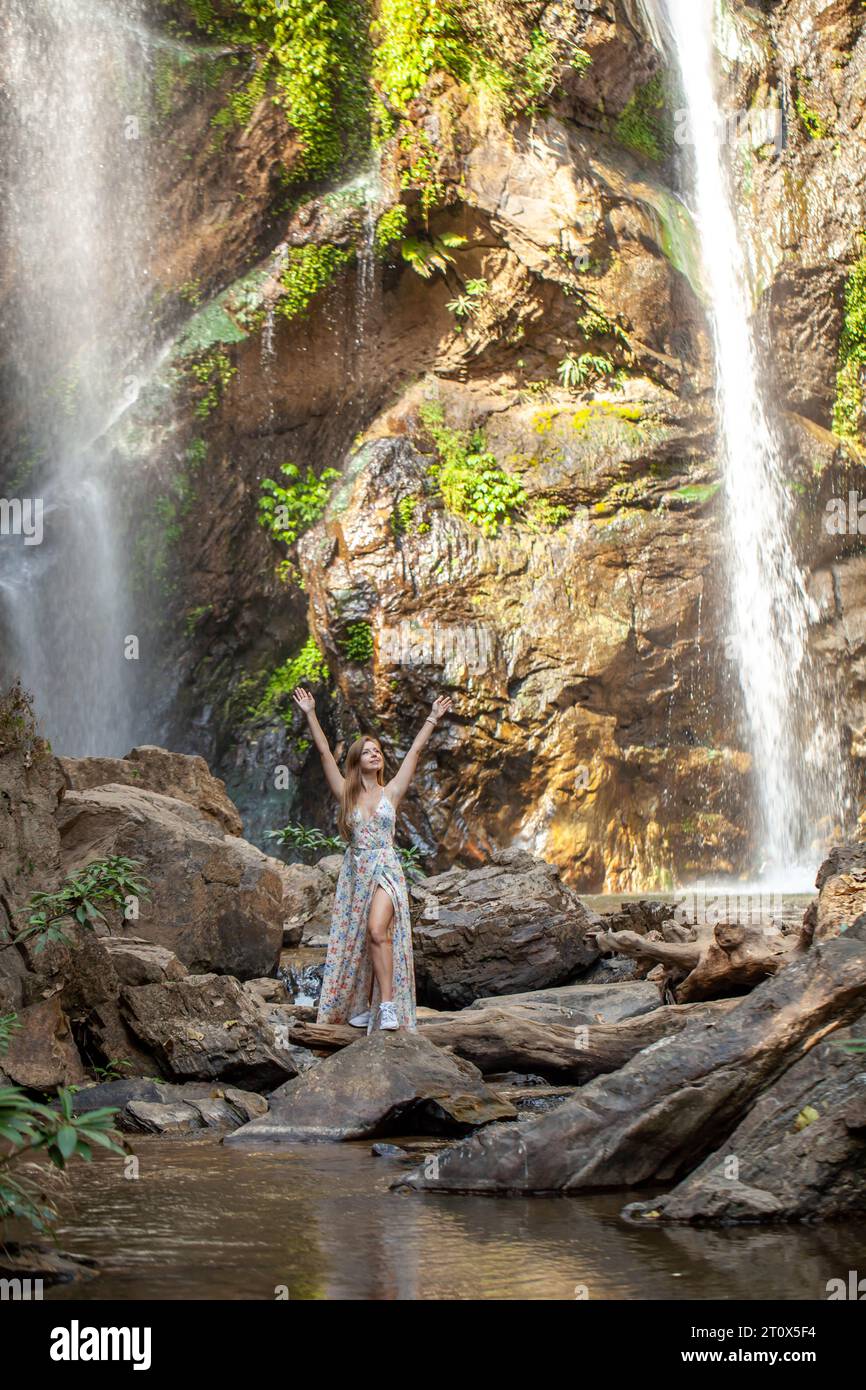 Woman in flowing dress by tropical waterfall Stock Photo - Alamy