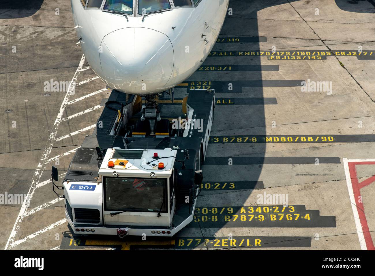 High angle view of aircraft parked at jet bridge on yellow airport gate ...