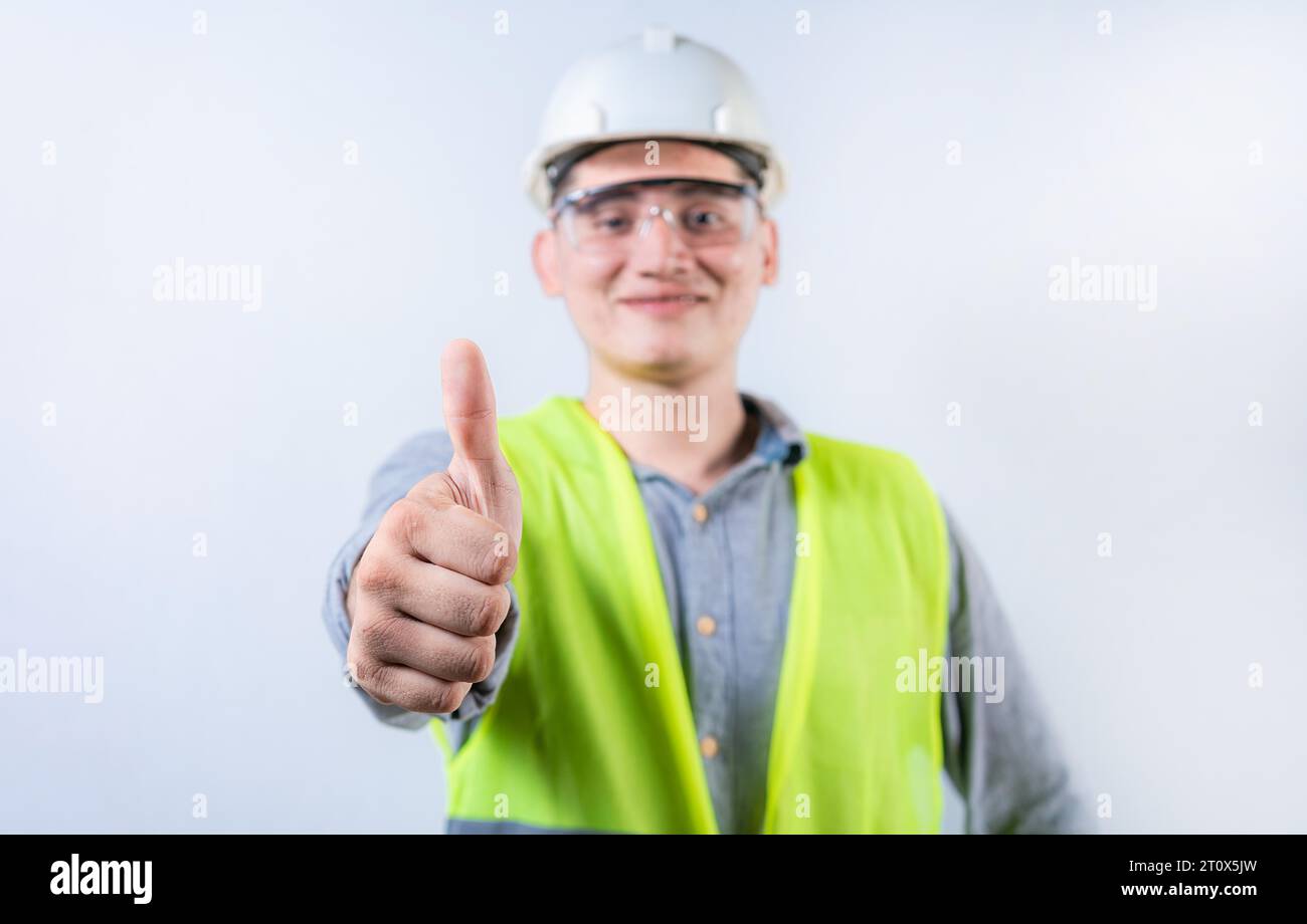 Smiling young engineer gesturing approval with thumb. Cheerful engineer ...