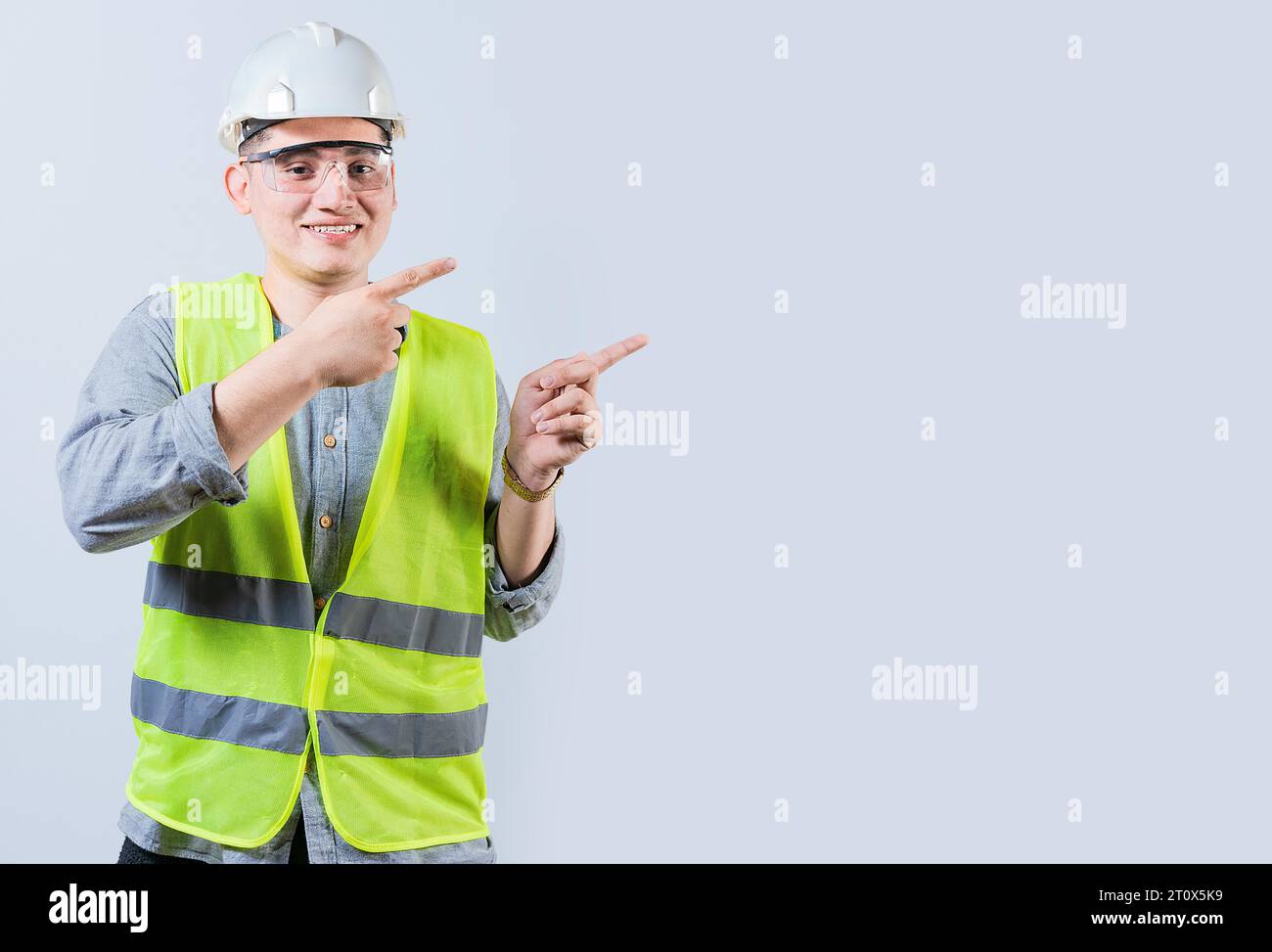 Cheerful engineer with helmet pointing aside isolated. Handsome ...