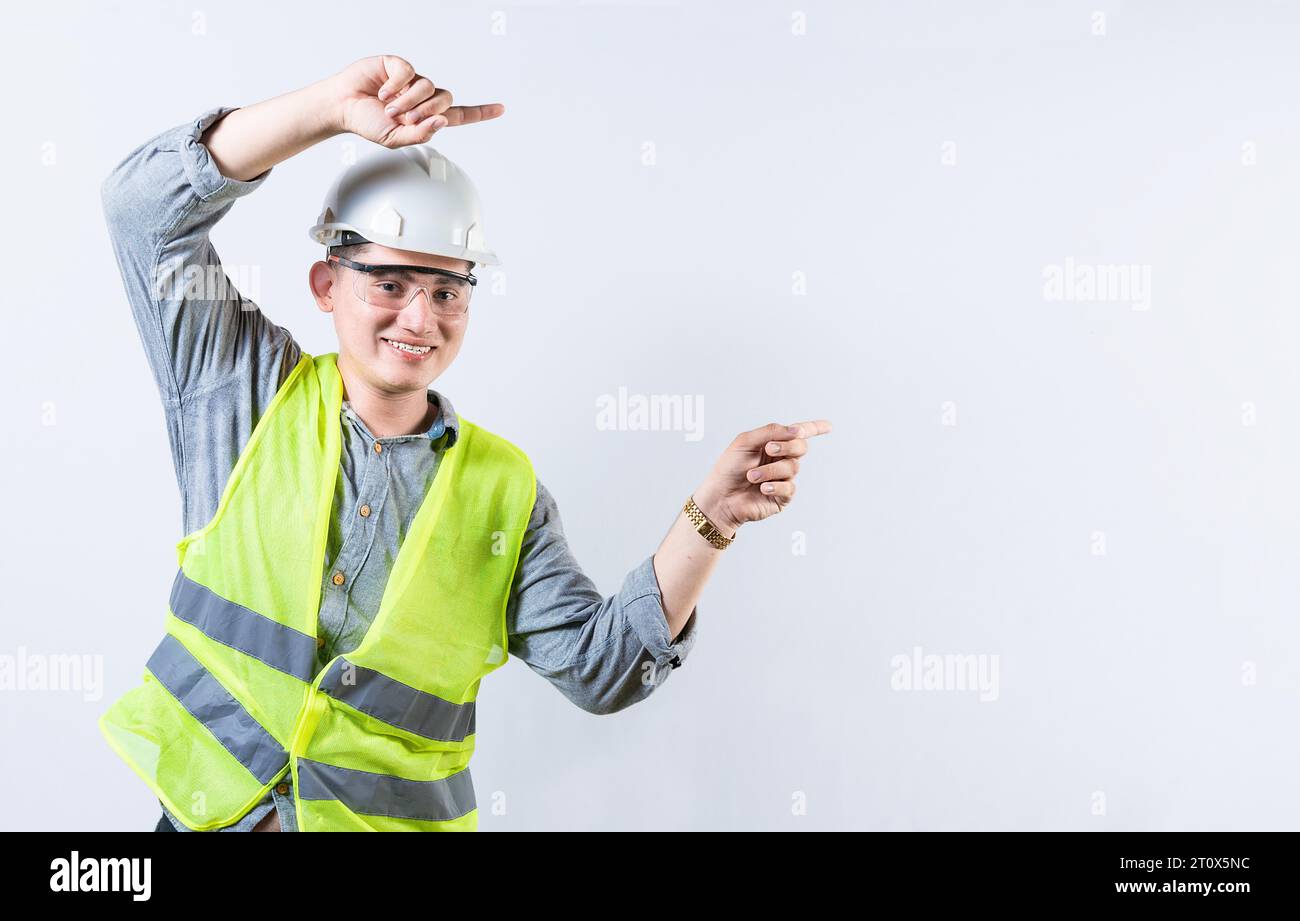 Portrait of smiling engineer pointing aside isolated. Handsome engineer ...