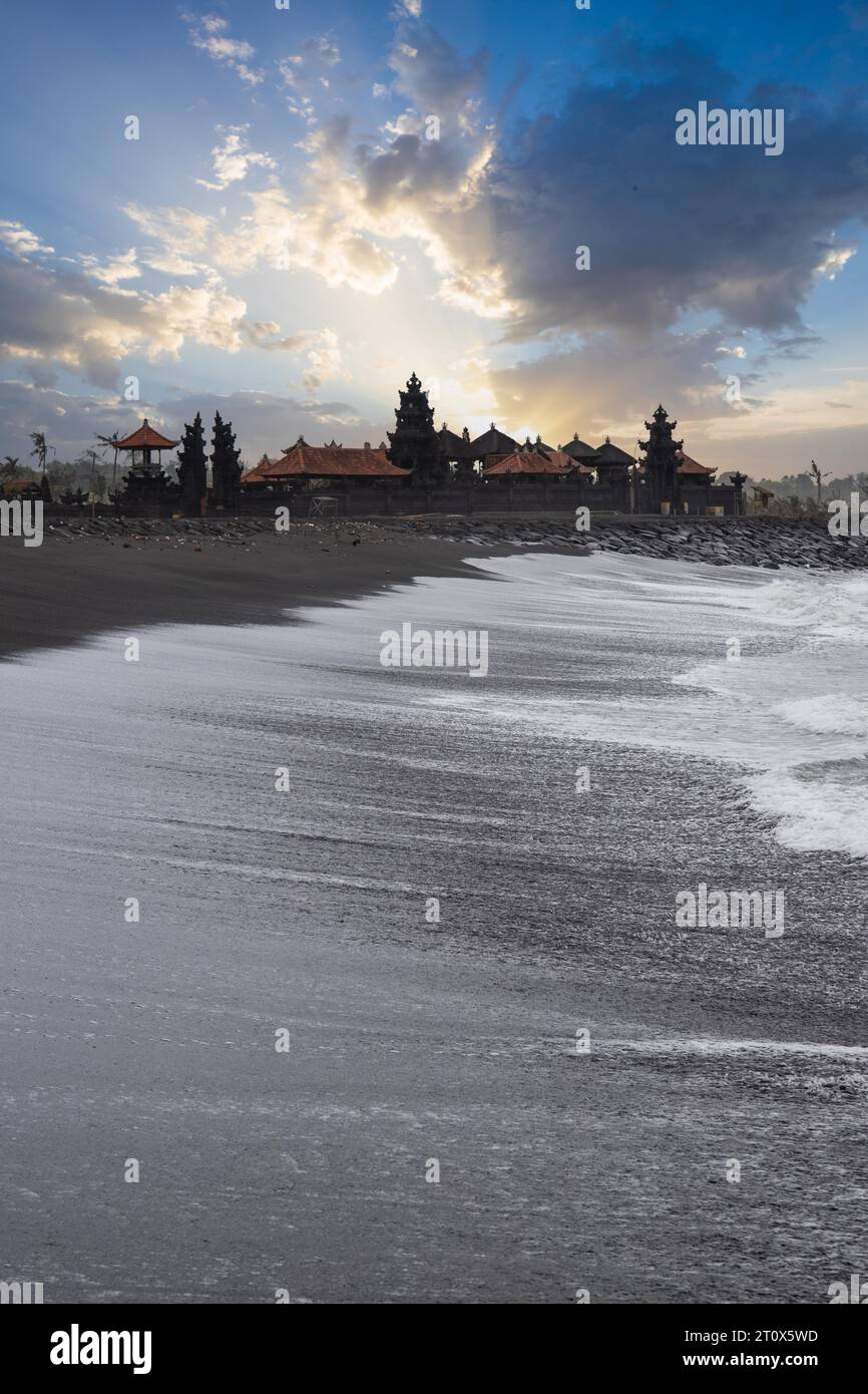Hindu temple on a black sand beach directly by the sea. Evening ...