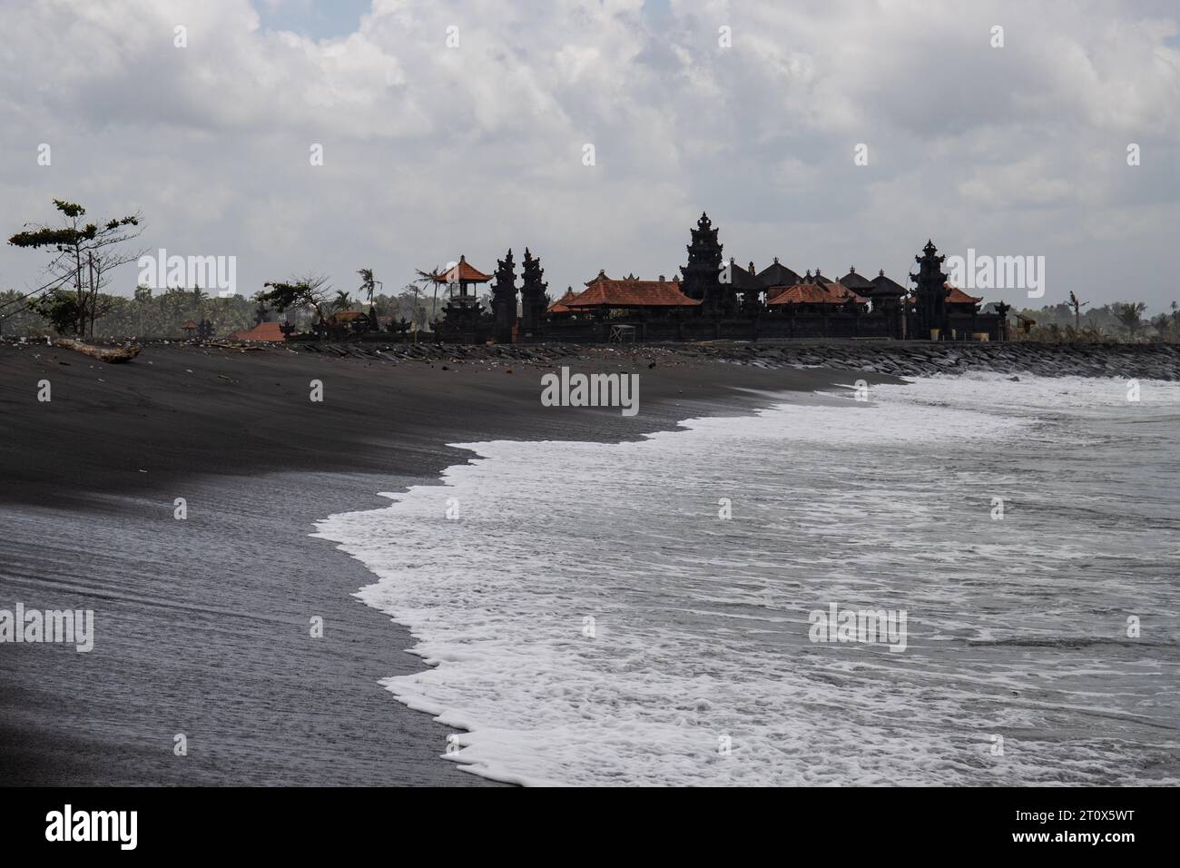 Hindu temple on a black sand beach directly by the sea. Evening ...