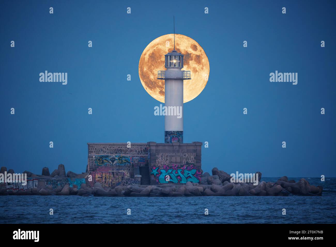 Full moon twilight landscape over sea horizon and lighting lighthouse ...