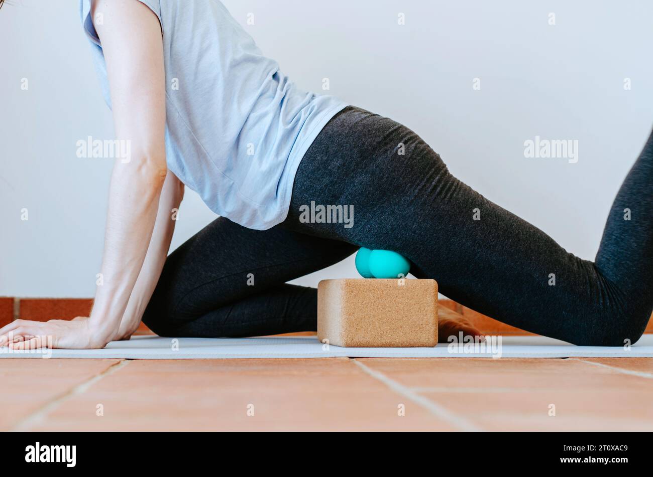 Person doing self myofascial release on front hip muscles with ball on ...