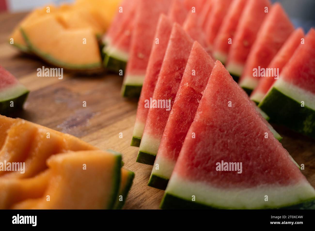 Party guests have triangular shaped slices watermelon set up on a ...