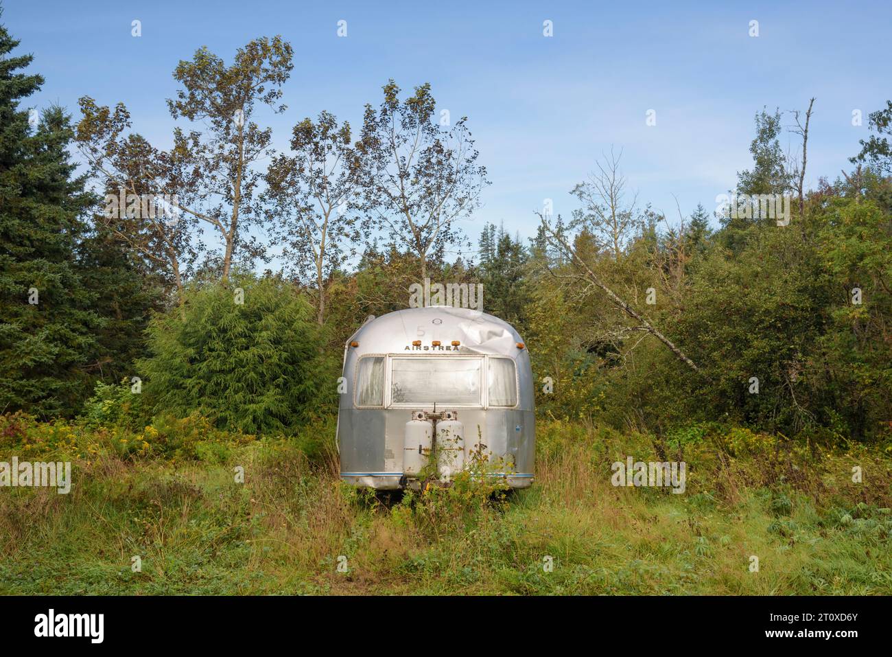 Old vintage Airstream camper abandoned in a field Stock Photo - Alamy