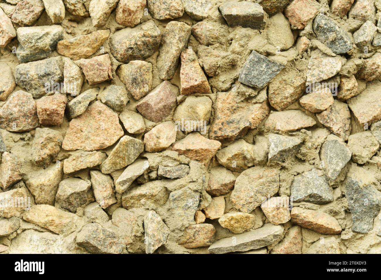 Old rough stone wall made of various square natural stones in beige ...