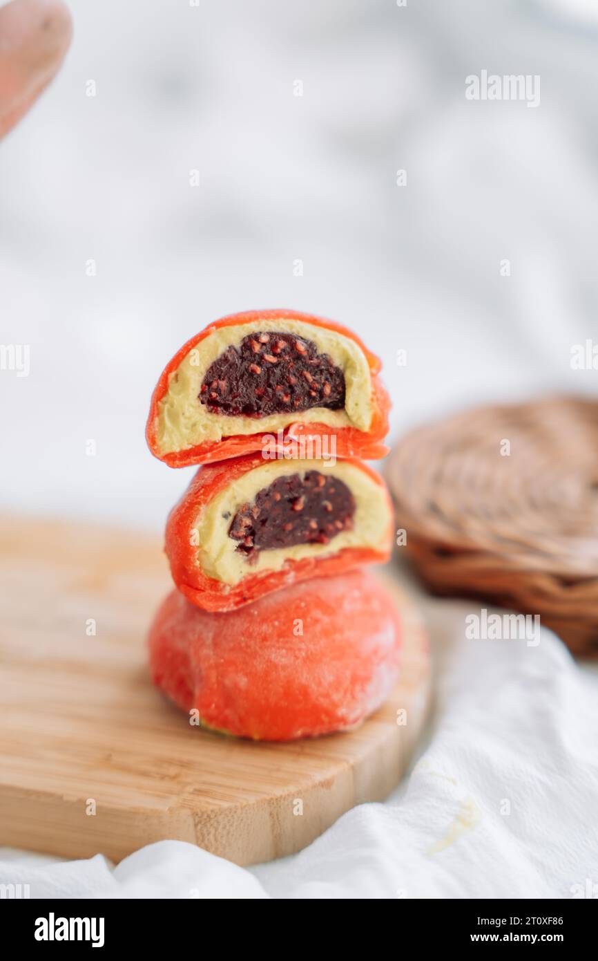 Orange mochi with berry filling on a wooden board Stock Photo - Alamy