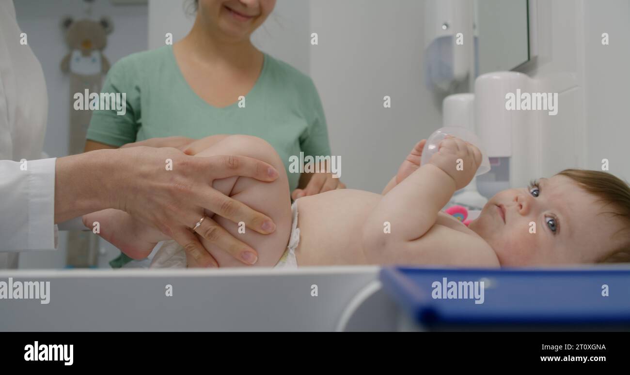 Mother with baby on appointment with pediatrician. Female doctor checks ...