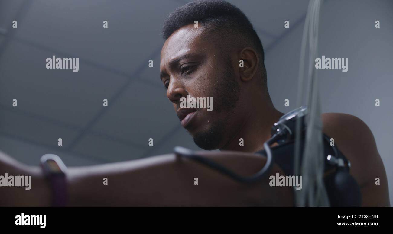 African American man with tonometer and sensors pedals orbitrek in ...