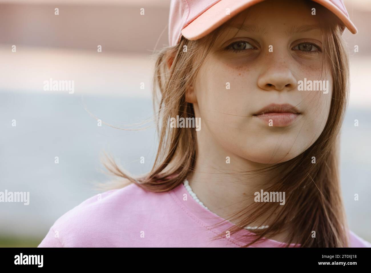 Close up portrait of a ten year old girl, smiling up at the camera ...