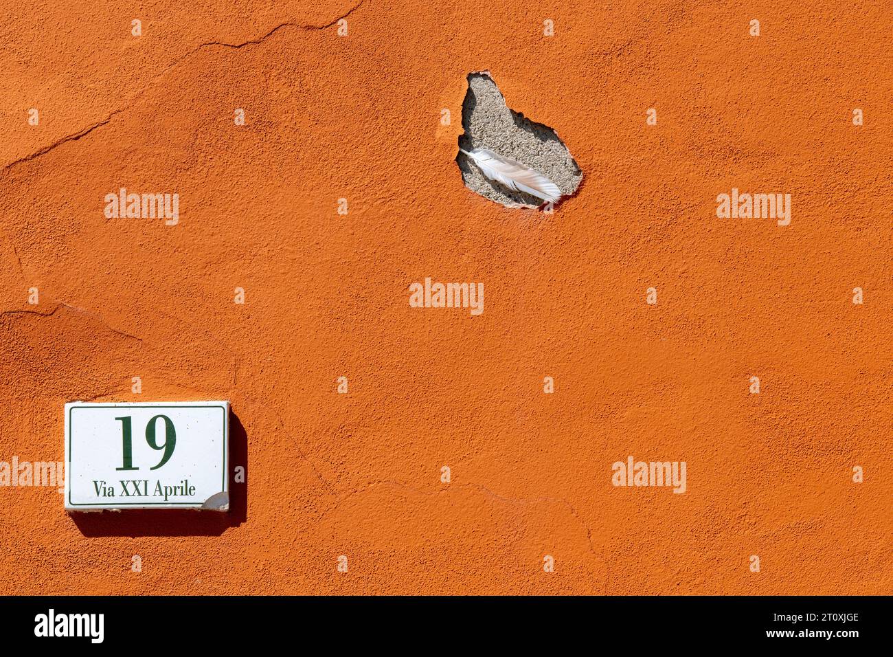 Ghizzano, Italy-June 8, 2023; Detail of flaking off orange-brown wall ...
