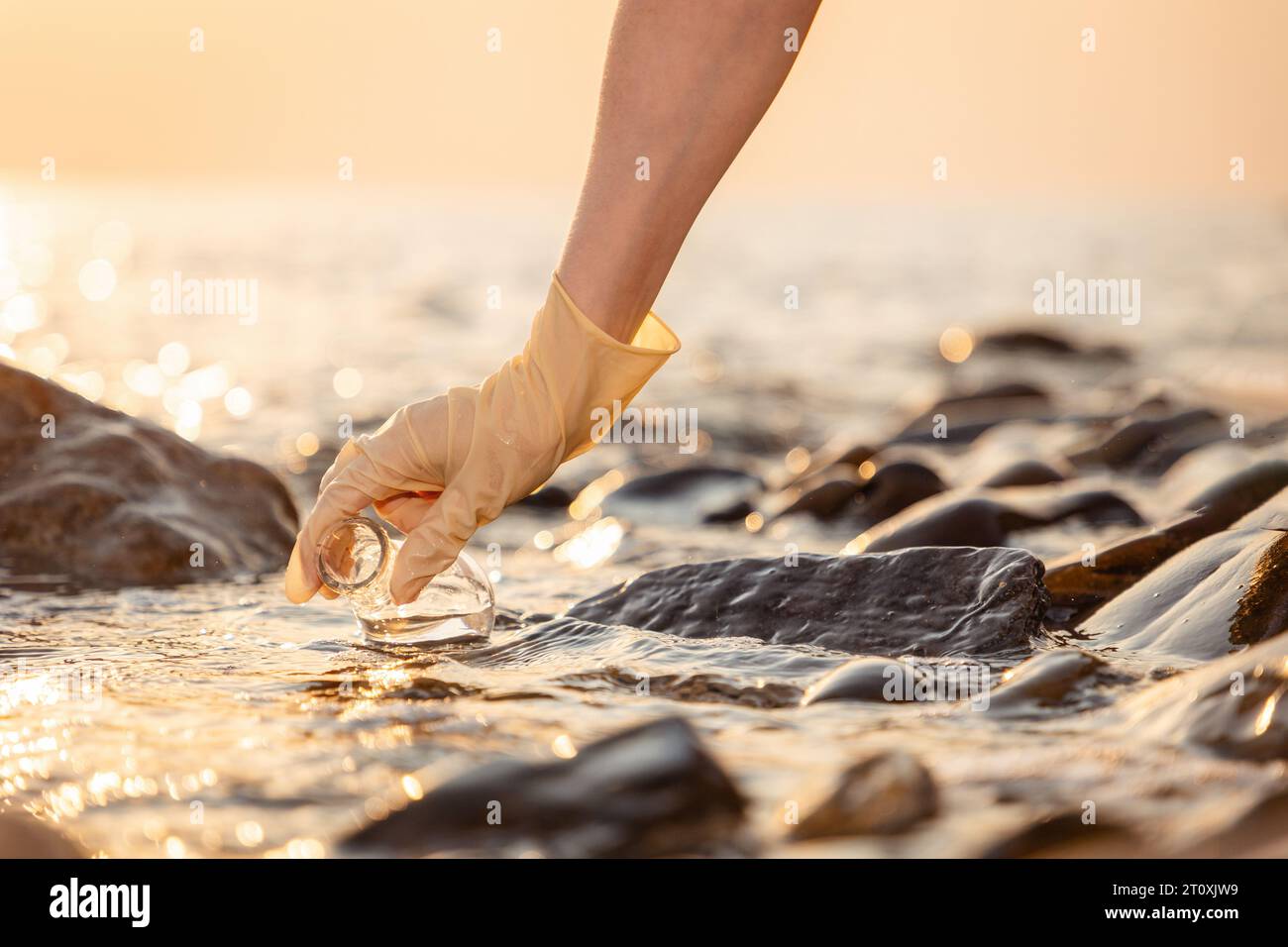 Hand wearing rubber glove intake test sample flask of water from river ...
