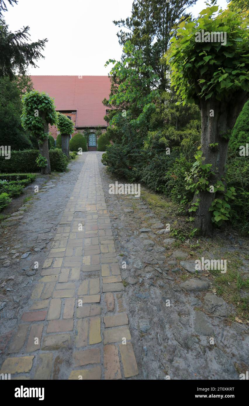 A very long stone footpath leading to an old church building Stock ...