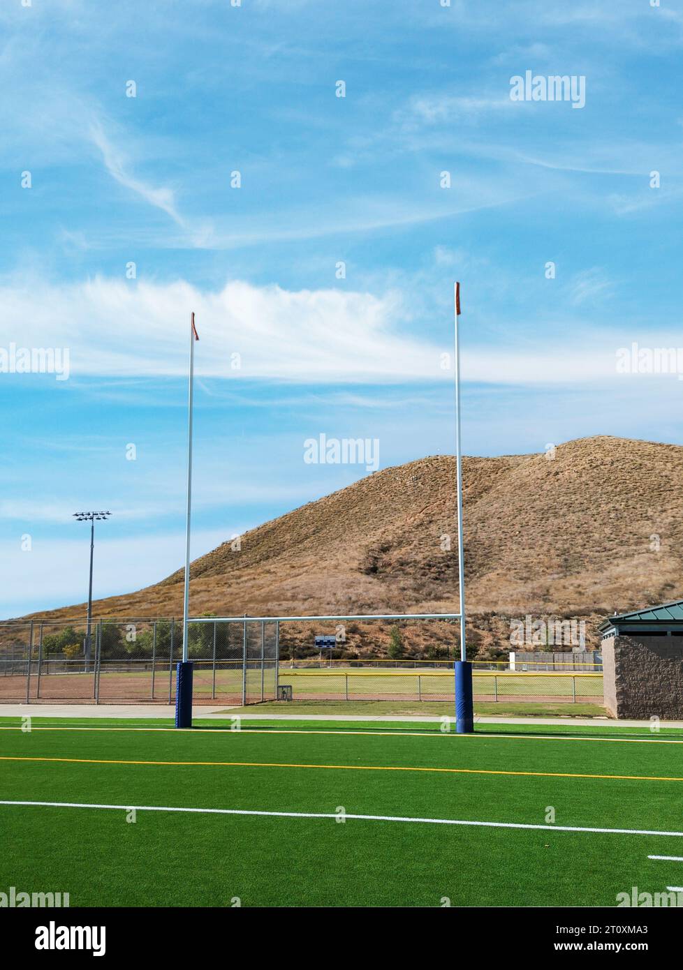 American football goal posts with hill and blue sky Stock Photo - Alamy