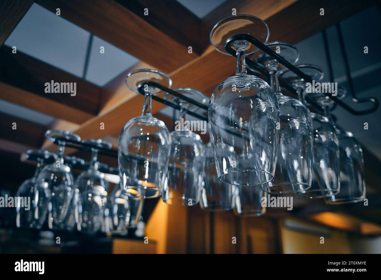 Wine glasses hang above bar counter Stock Photo - Alamy