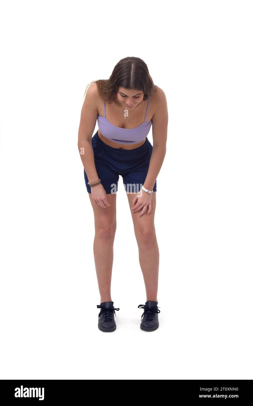 front view of a young girl crouched and looking the floor on white ...