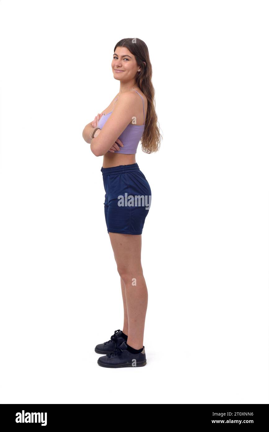 side view of a young girl standing and arms crossed and looking at ...