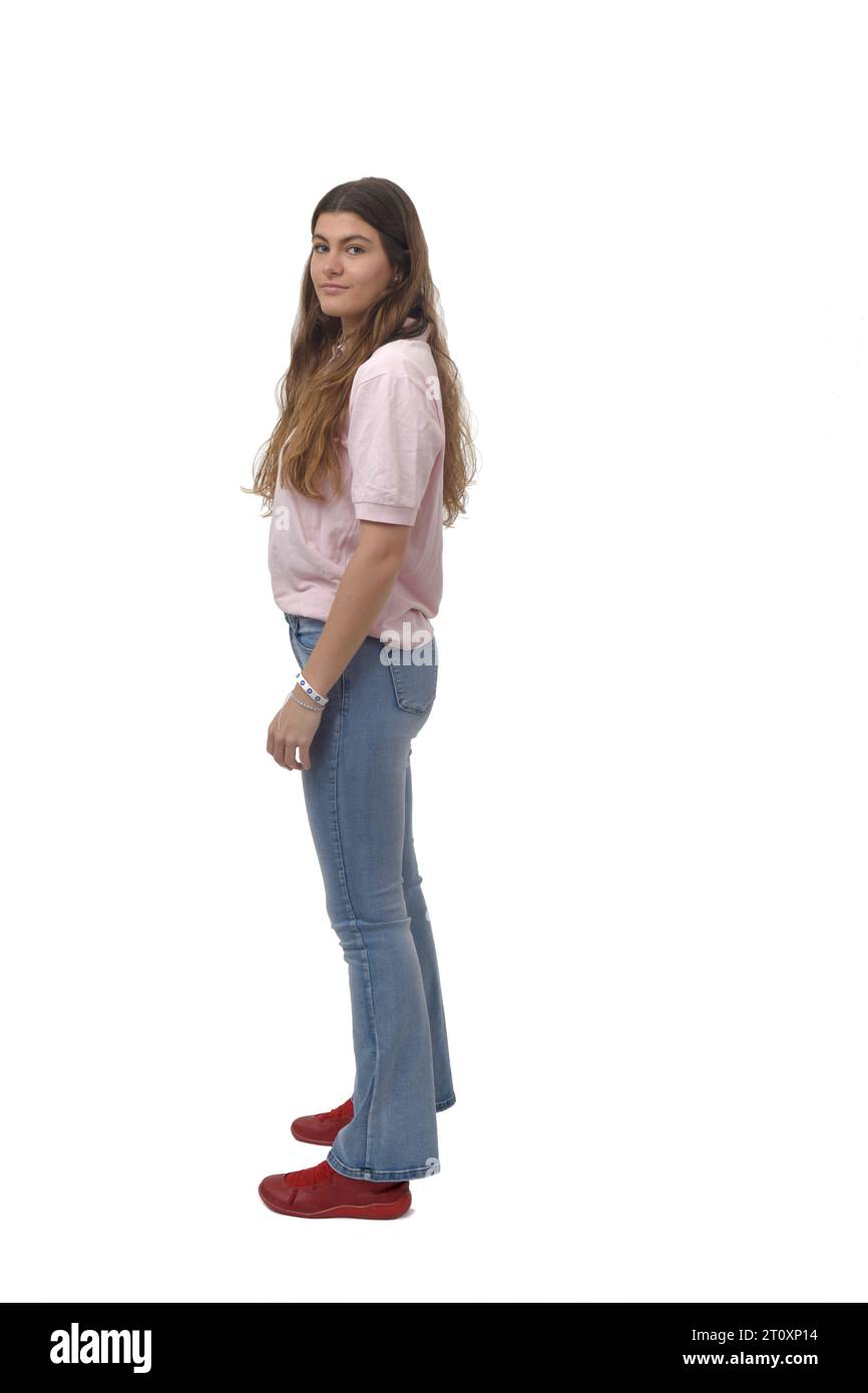 side view of a young girl standing and looking at camera on white ...