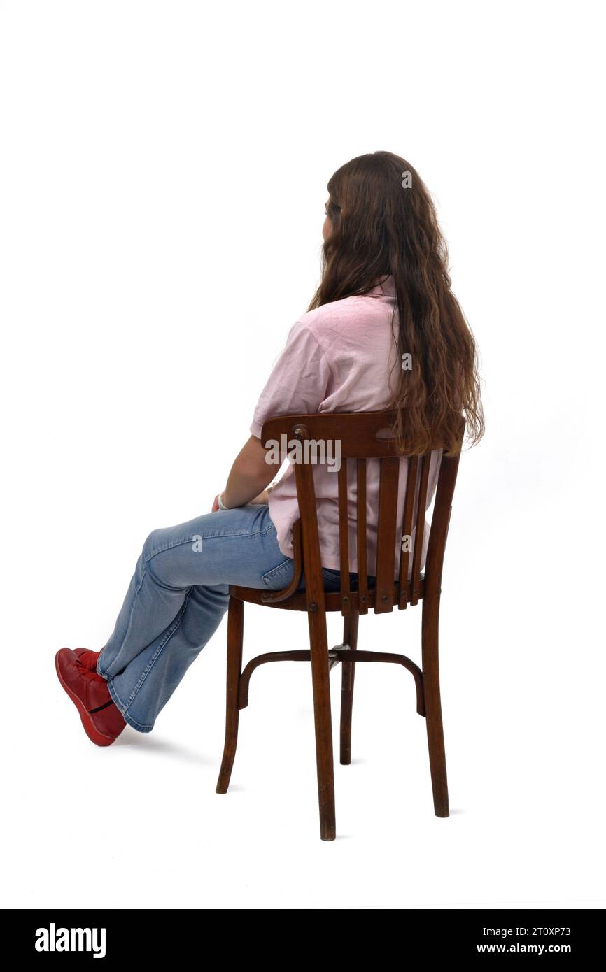 back and side view of a young girl sitting on chair on white background ...