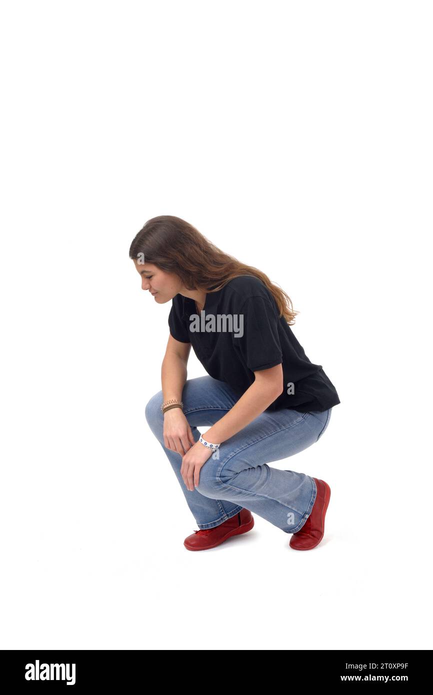 side view of a young girl crouching and searching at the ground on ...