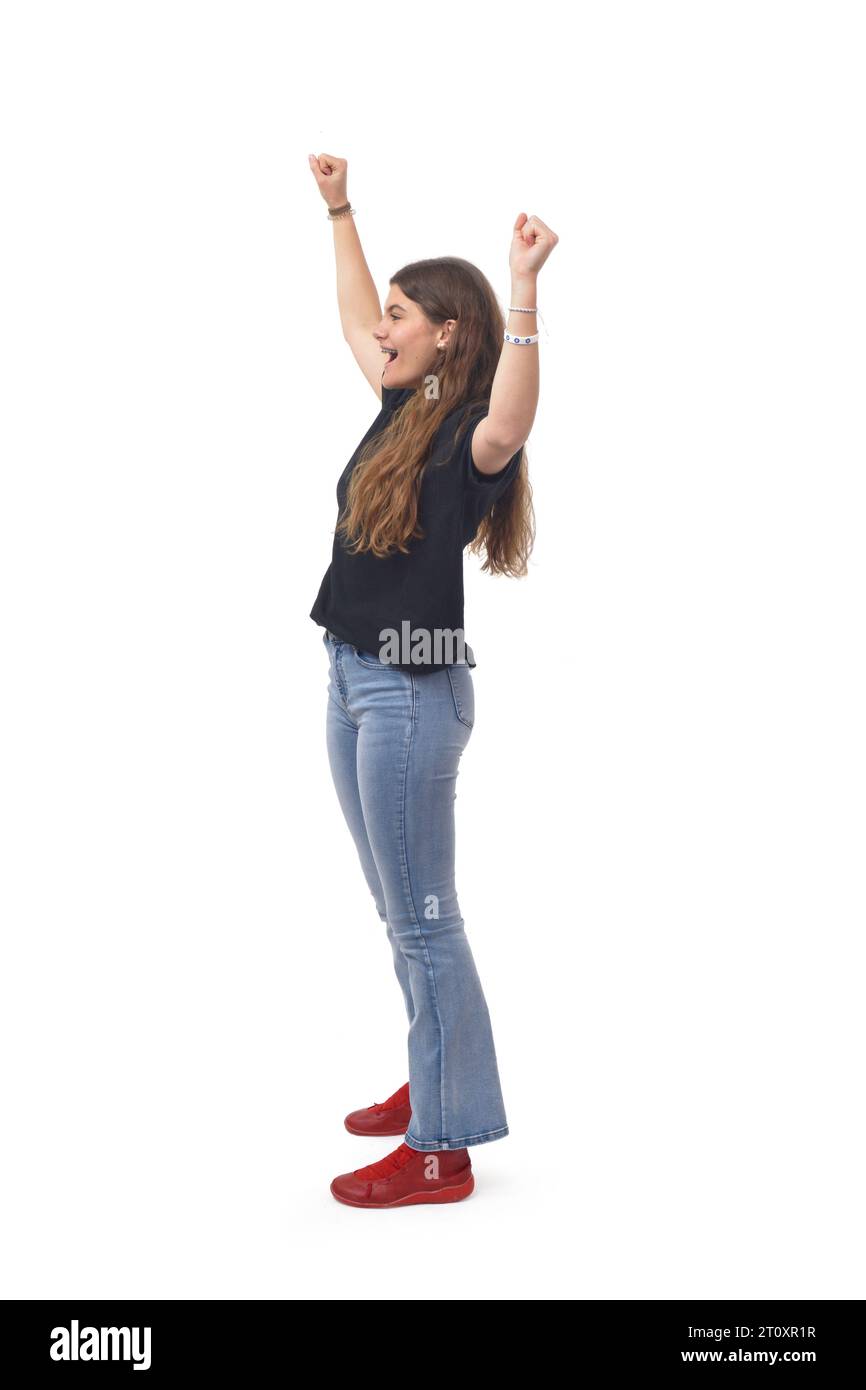 side view of a happy young girl with arms raised on white background ...