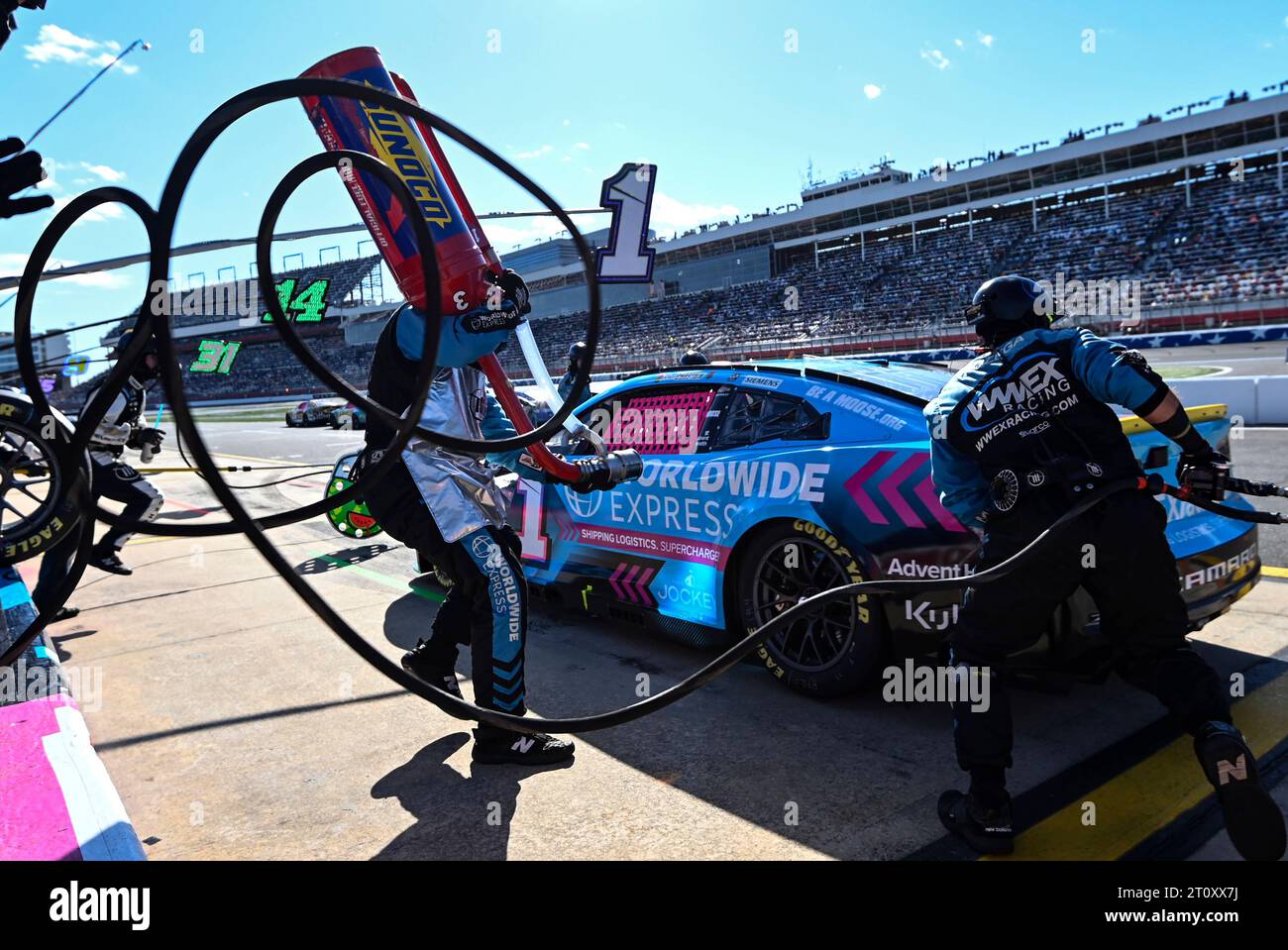 The pit crew for Ross Chastain (1) rushes to complete a pit stop during ...