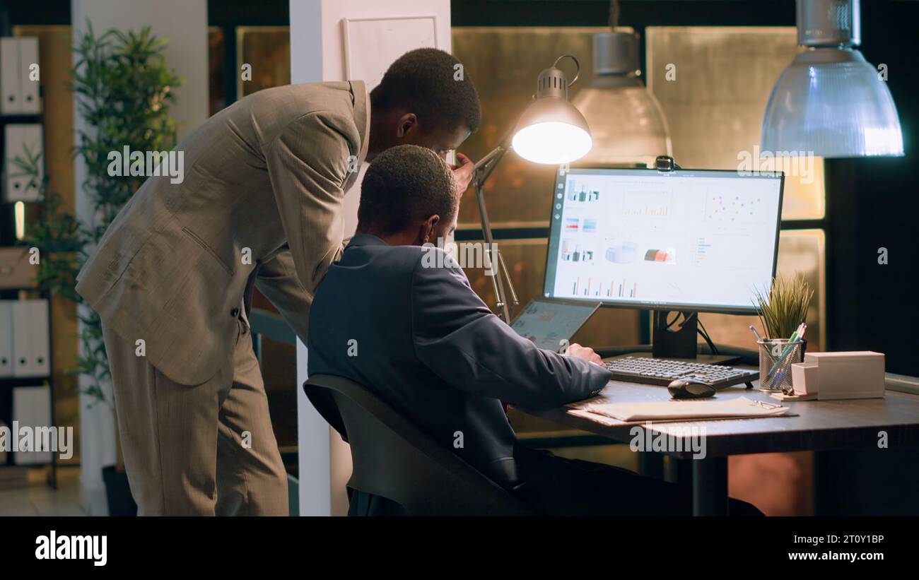 Coworkers in office crosschecking datasets, comparing financial charts ...