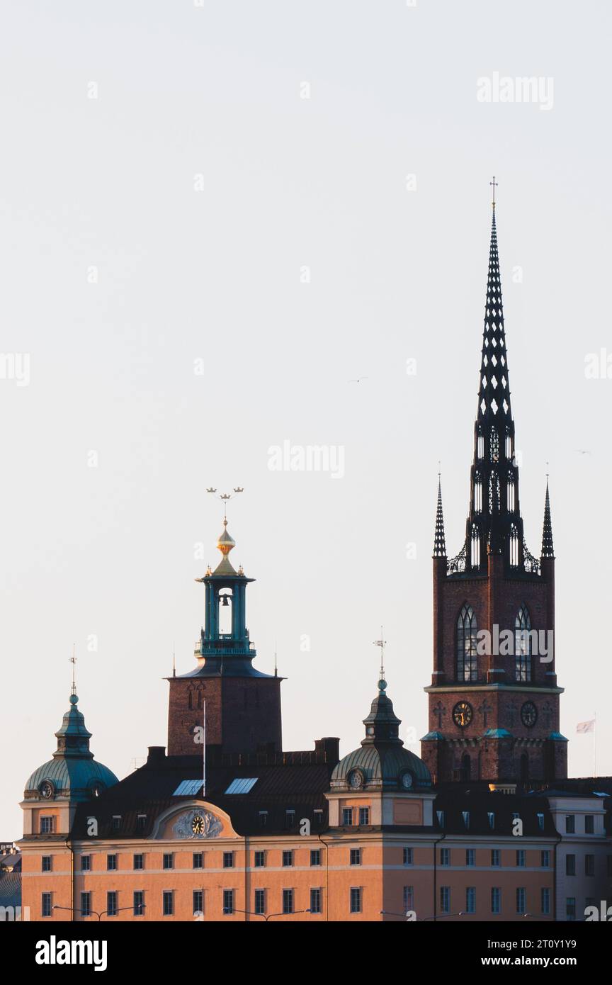 An aerial view of a grand building in the sun with a clock tower atop ...