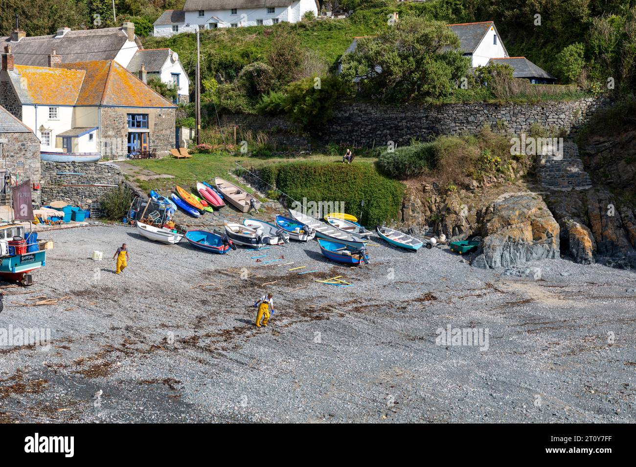 Cadgwith cove fishing village in Cornwall, two fishermen working on the ...