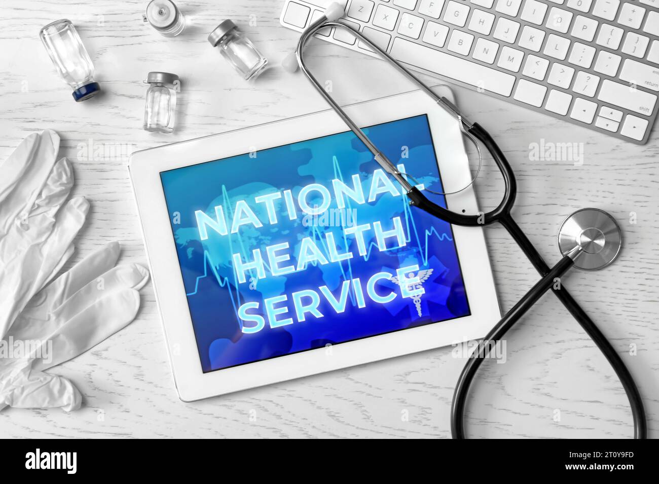 National health service (NHS). Tablet with text, stethoscope, drugs ...
