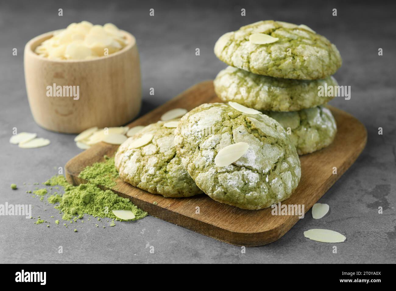 Tasty matcha cookies, almond flakes and powder on grey table Stock ...