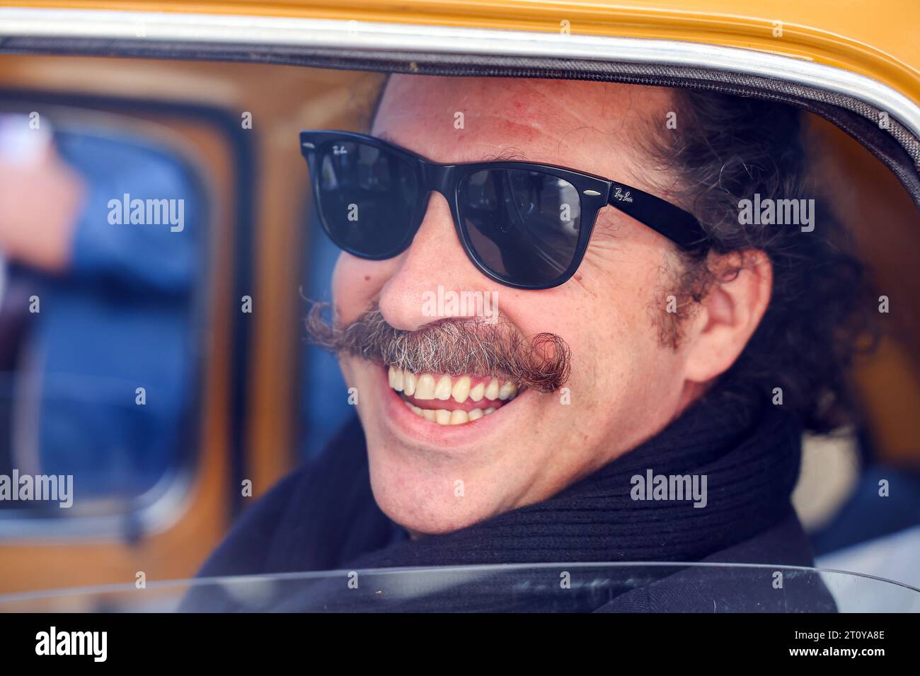 A man smiles while driving a 1970 Fiat up 5th Avenue in the Columbus ...