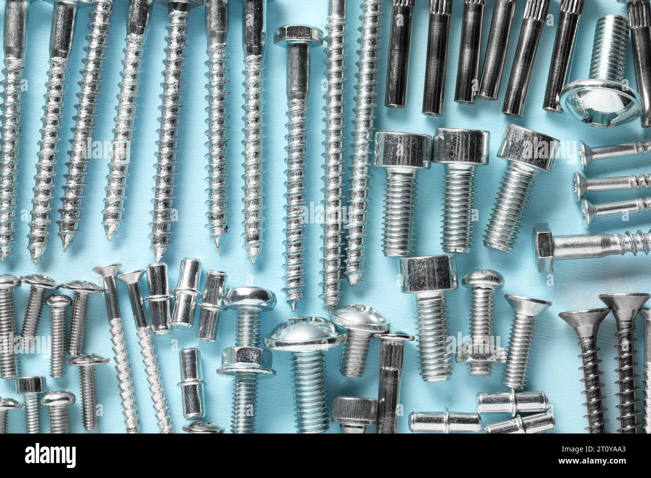Many different fasteners on light blue background, flat lay Stock Photo ...