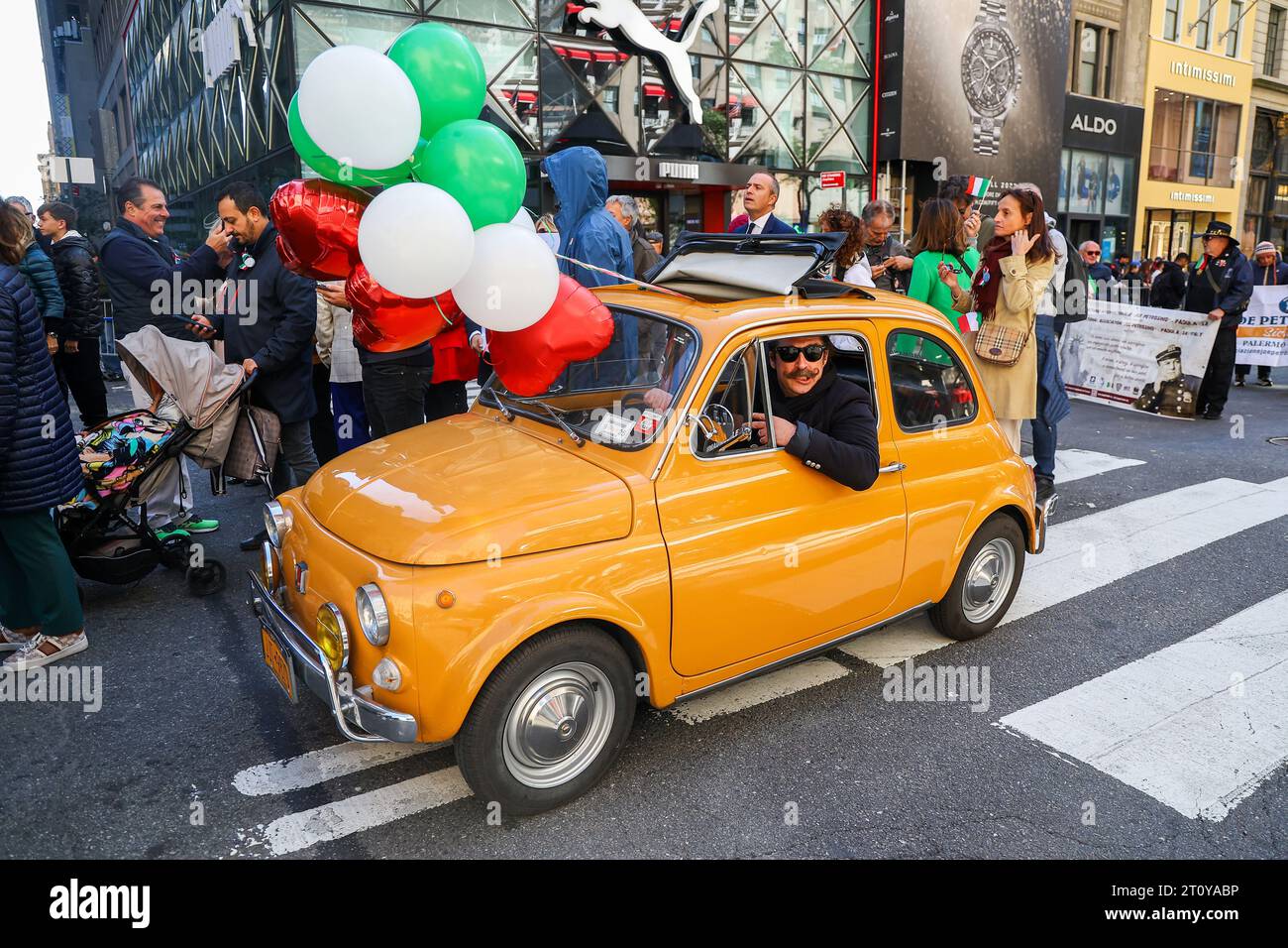 A man smiles while driving a 1970 Fiat up 5th Avenue in the Columbus ...
