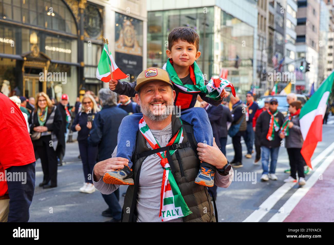 A youngster rides on the shoulder of his family while marching up 5th ...