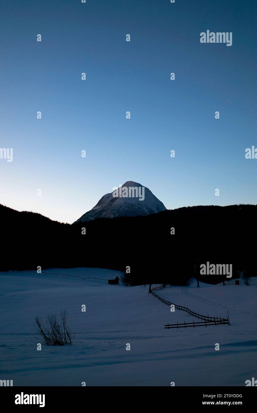 Colour photograph of a snow covered field, forest and mountain, Seefeld ...