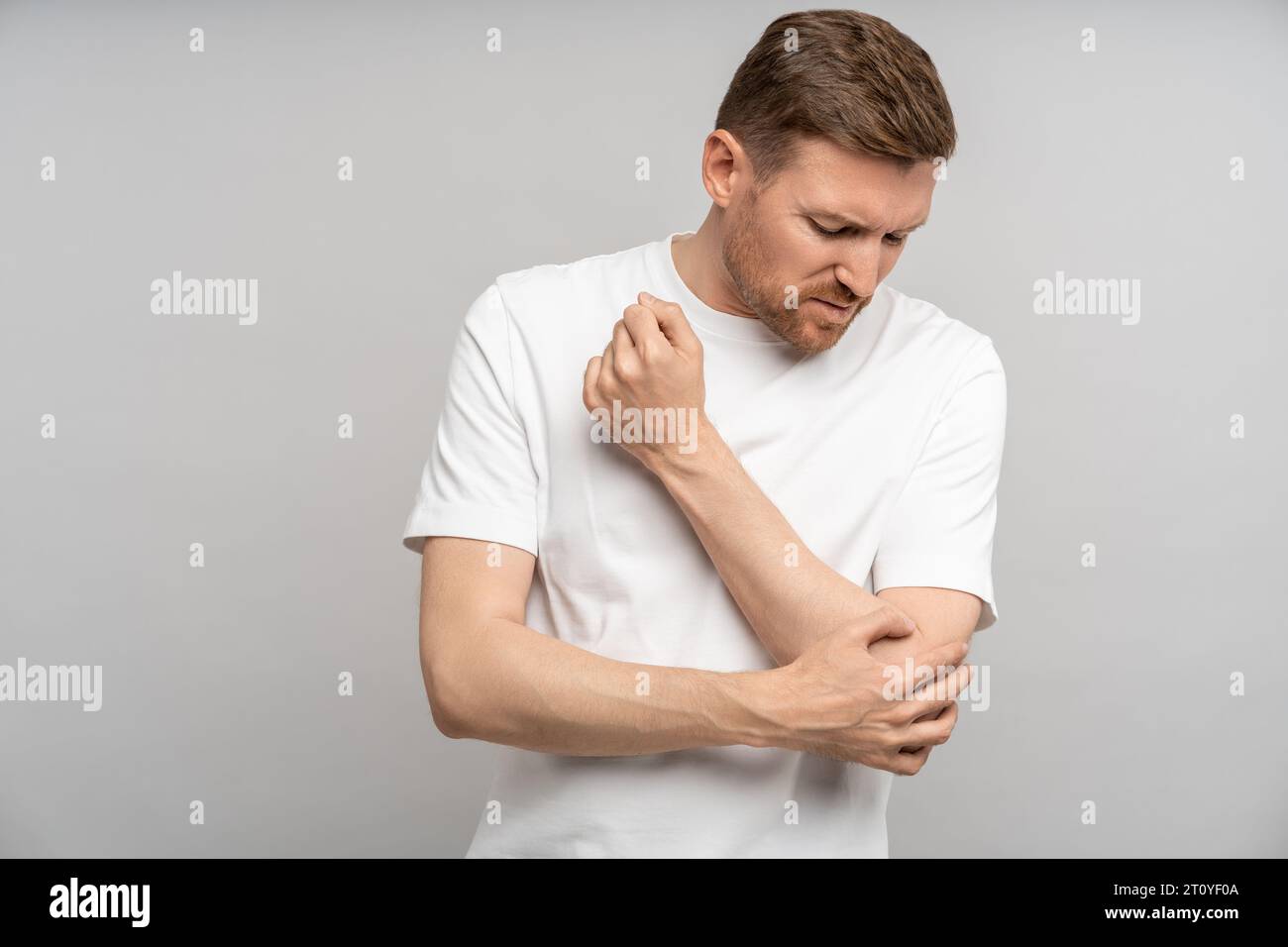 Unwell man holding aching elbow sore inflamed bones articulations ...