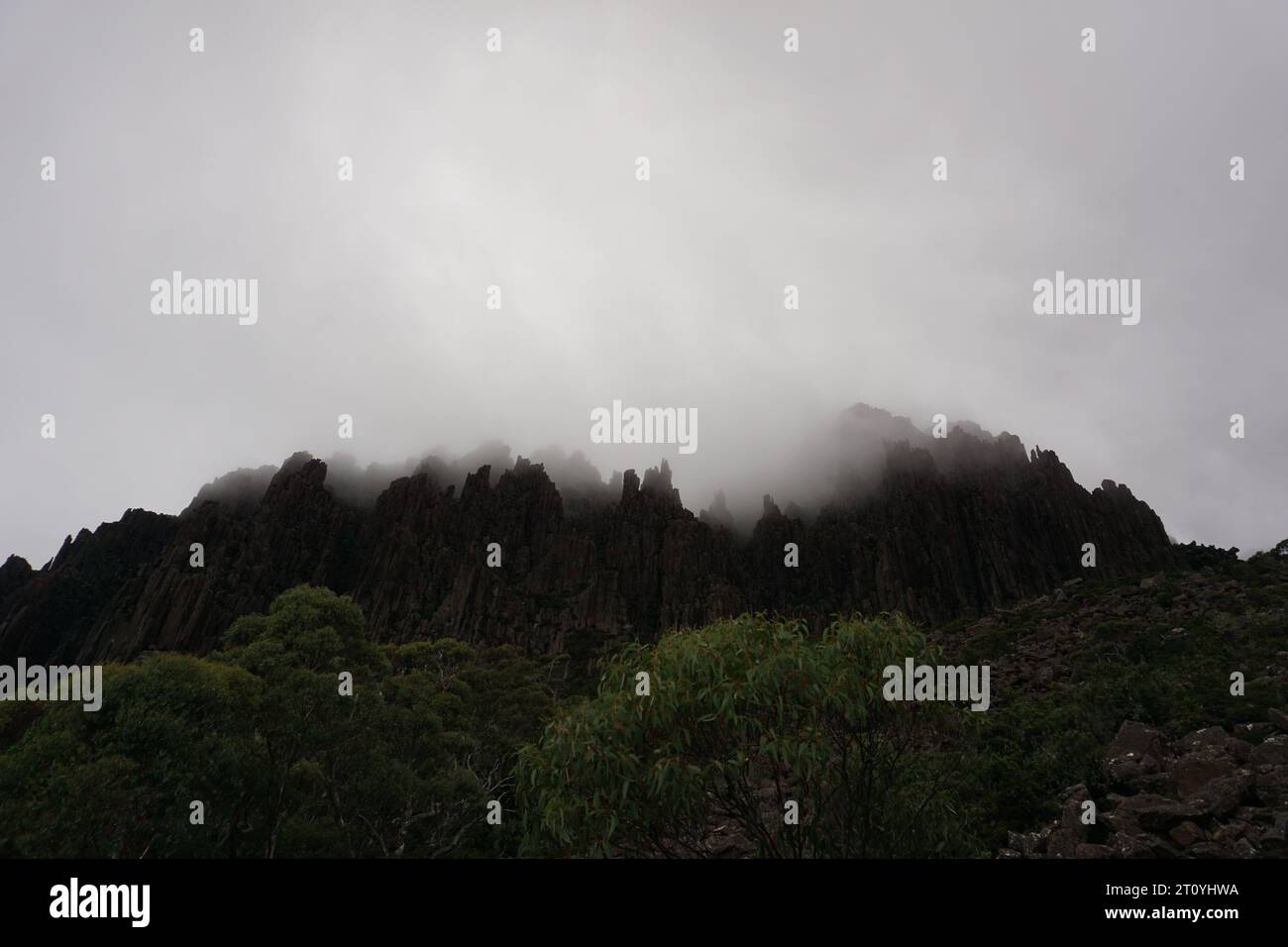 Dramatic moody view of rocky spiky ridge disappearing in low hanging ...
