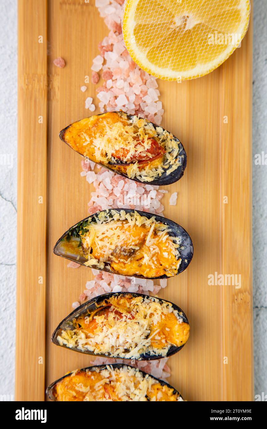 oysters scallops with red sea salt and citric acid on a wooden tray ...