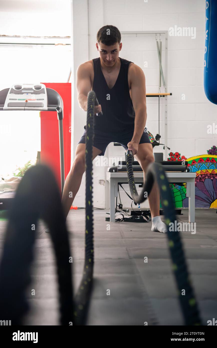 young boy training with battle ropes in a gymnasium adapted for this ...