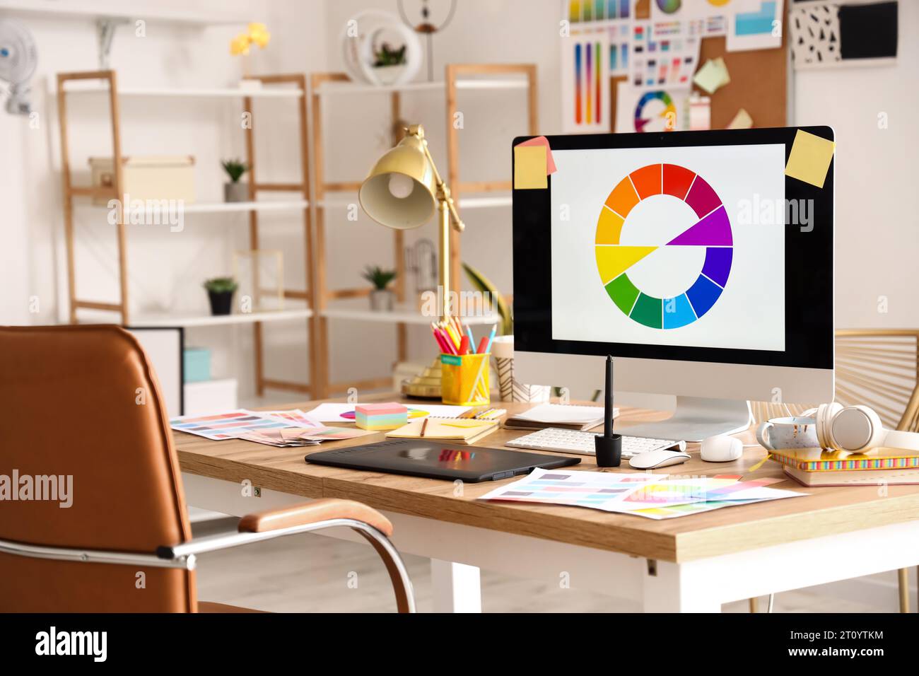 Graphic designer's workplace with computer, tablet and color palettes ...