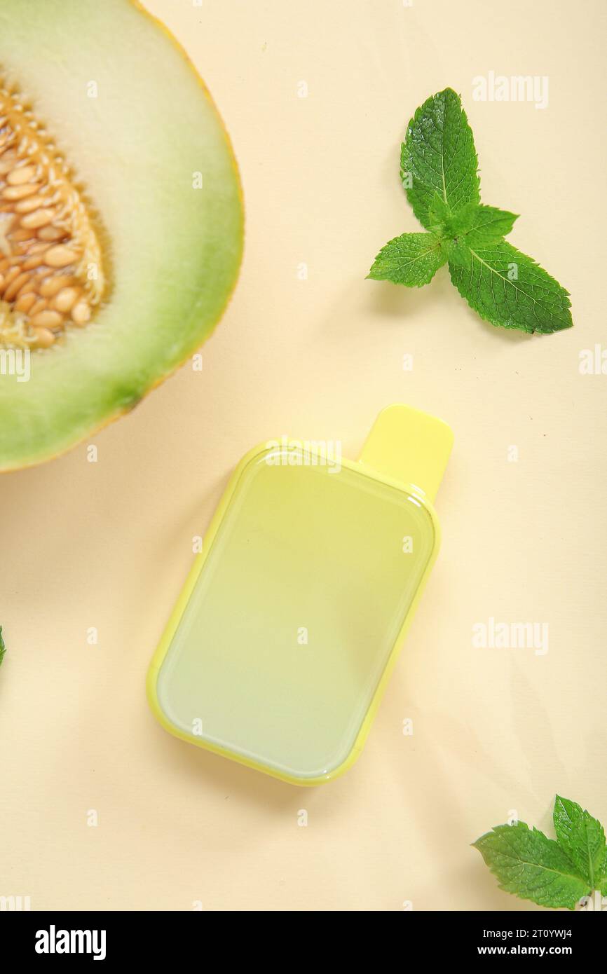 Electronic cigarette with melon and mint on yellow background Stock ...
