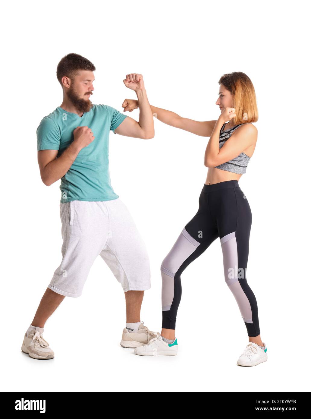 Young woman fighting with instructor of self-defence course on white ...